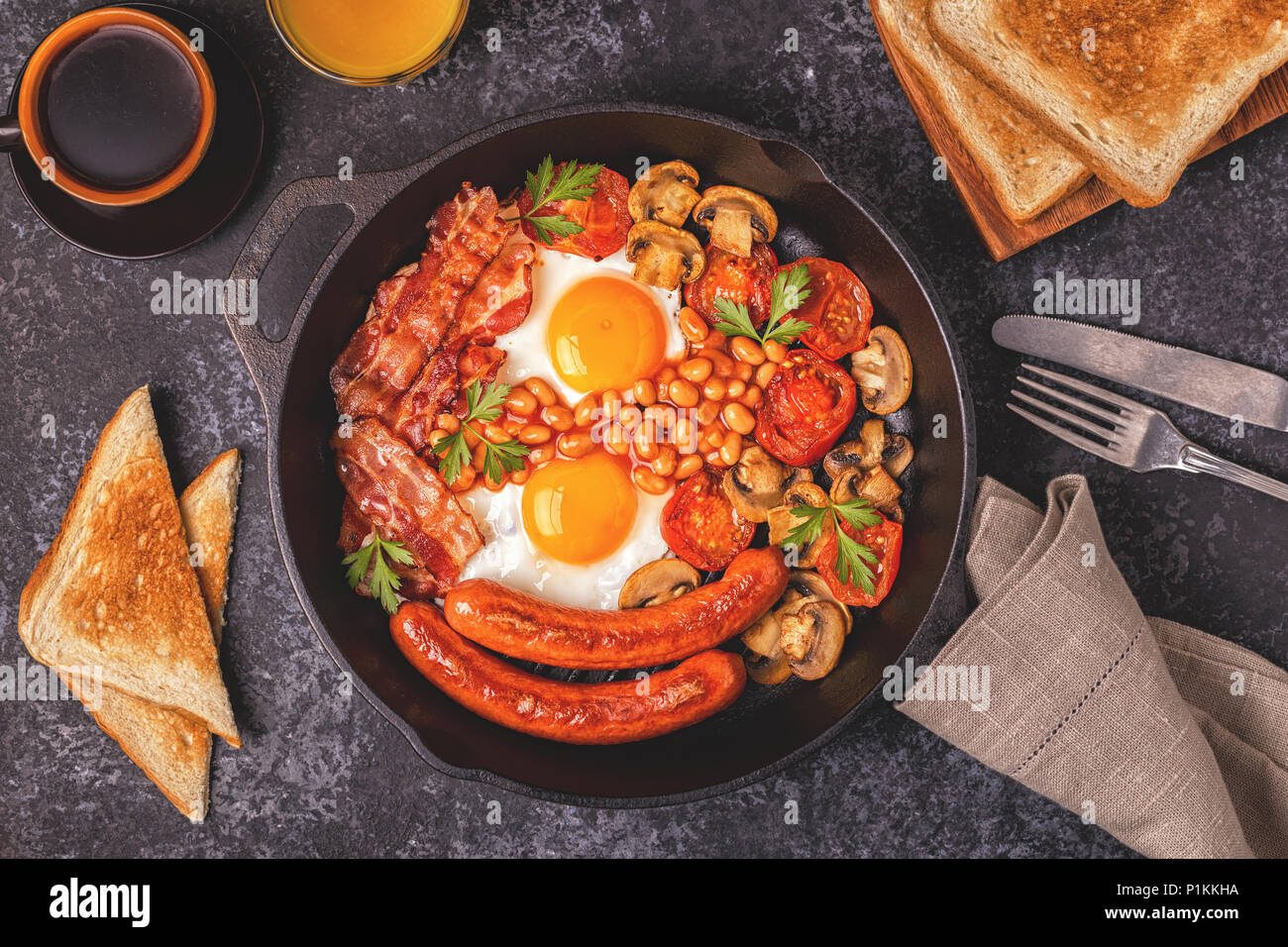 Traditional full English breakfast with fried eggs, sausages, beans ...