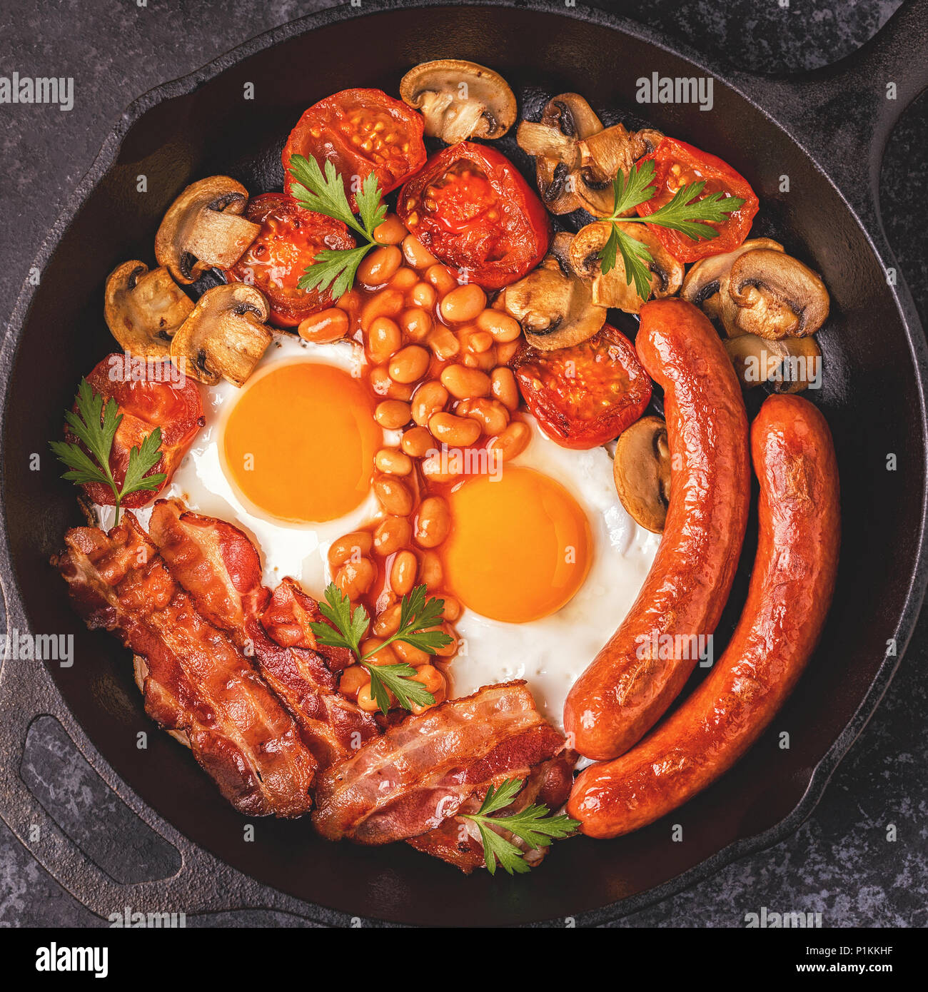 Traditional full English breakfast with fried eggs, sausages, beans ...