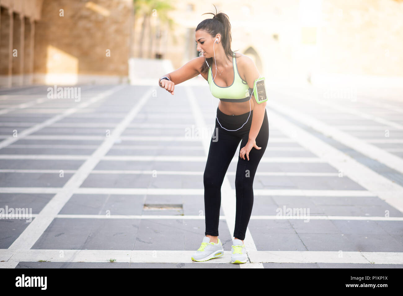 portrait of fit woman timing her heart rate with watch Stock Photo - Alamy