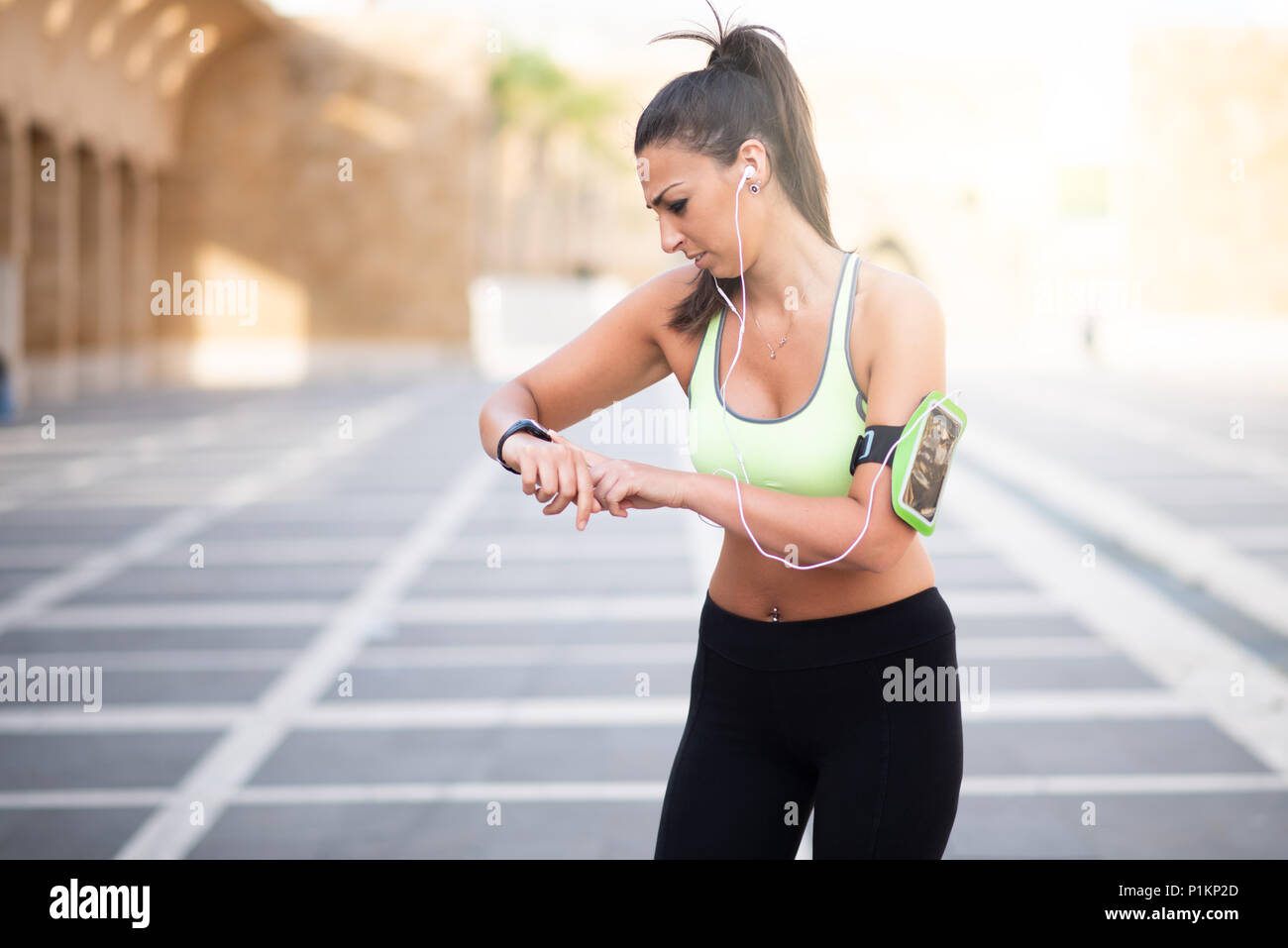 portrait of fit woman timing her heart rate with watch Stock Photo - Alamy