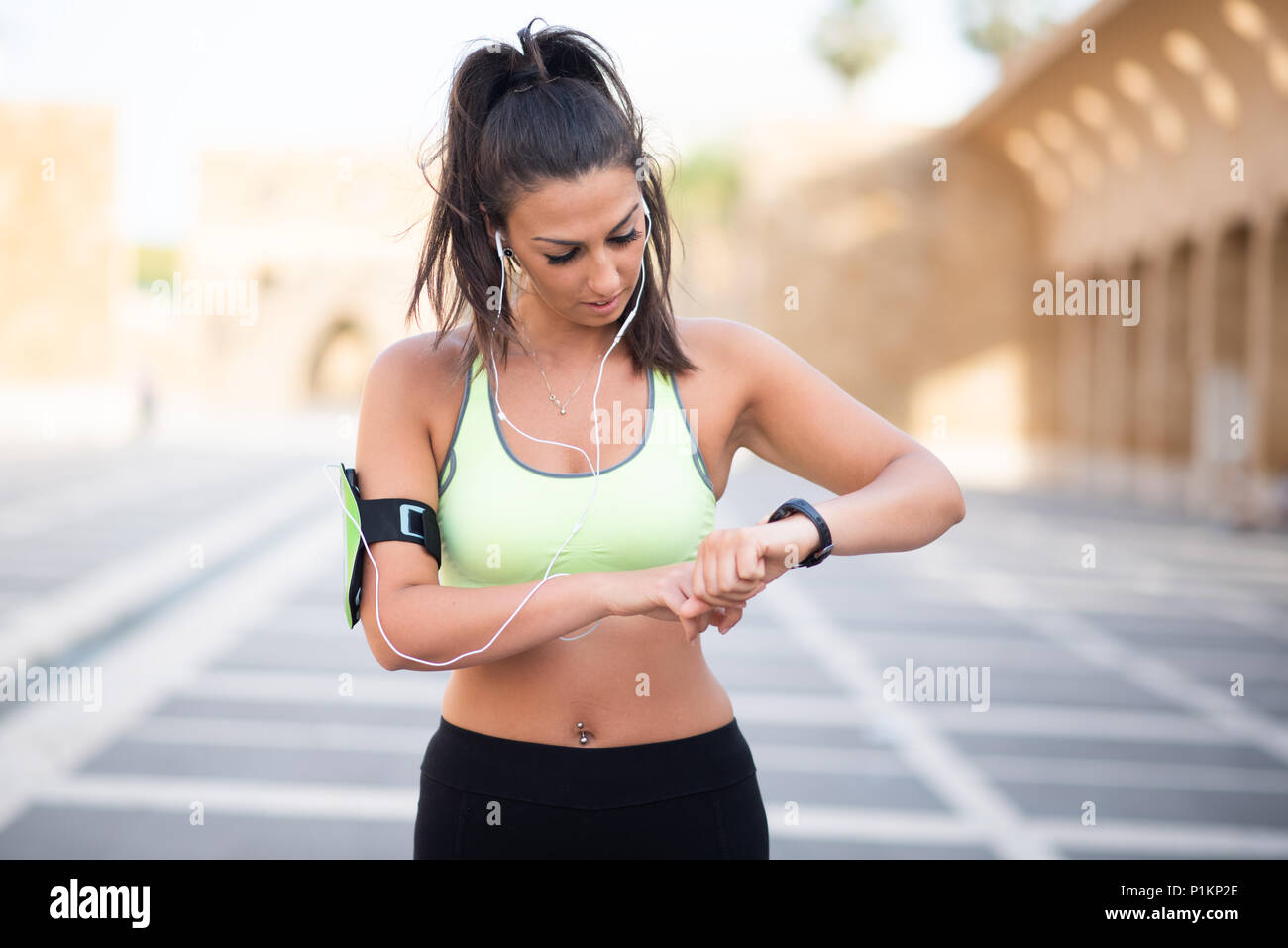 portrait of fit woman timing her heart rate with watch Stock Photo - Alamy