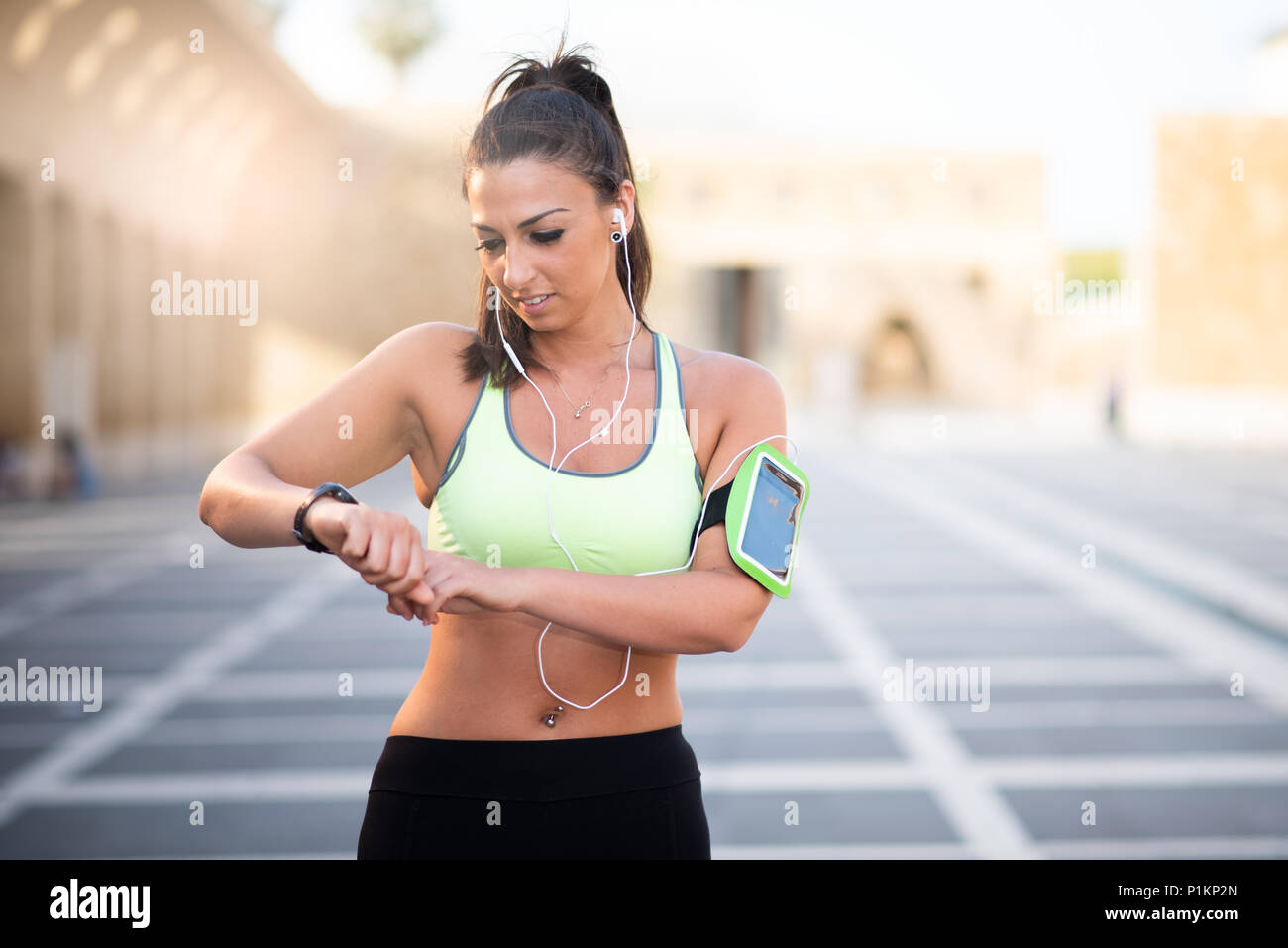 portrait of fit woman timing her heart rate with watch Stock Photo - Alamy