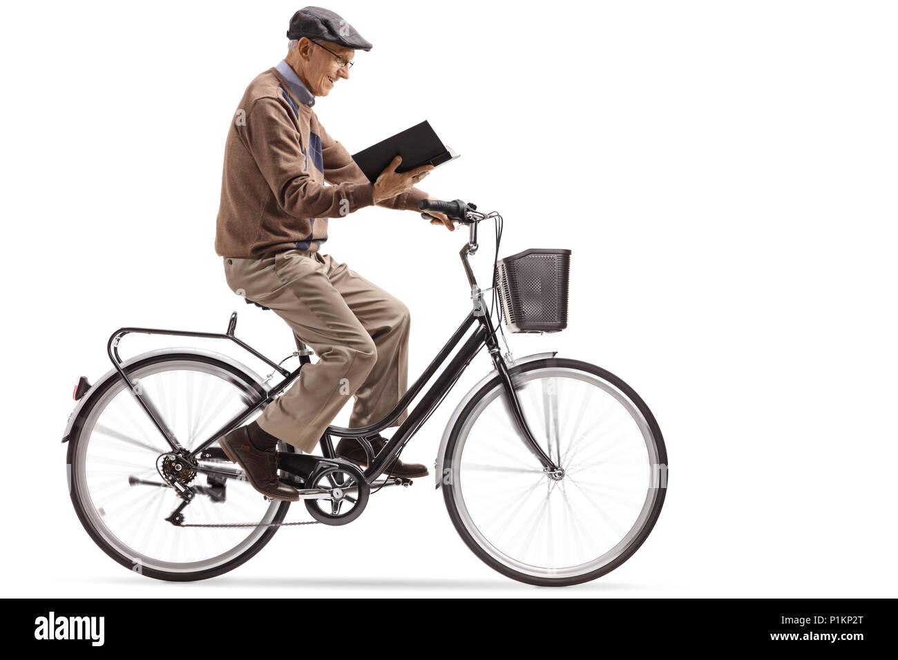 Elderly man riding a bicycle and reading a book isolated on white ...