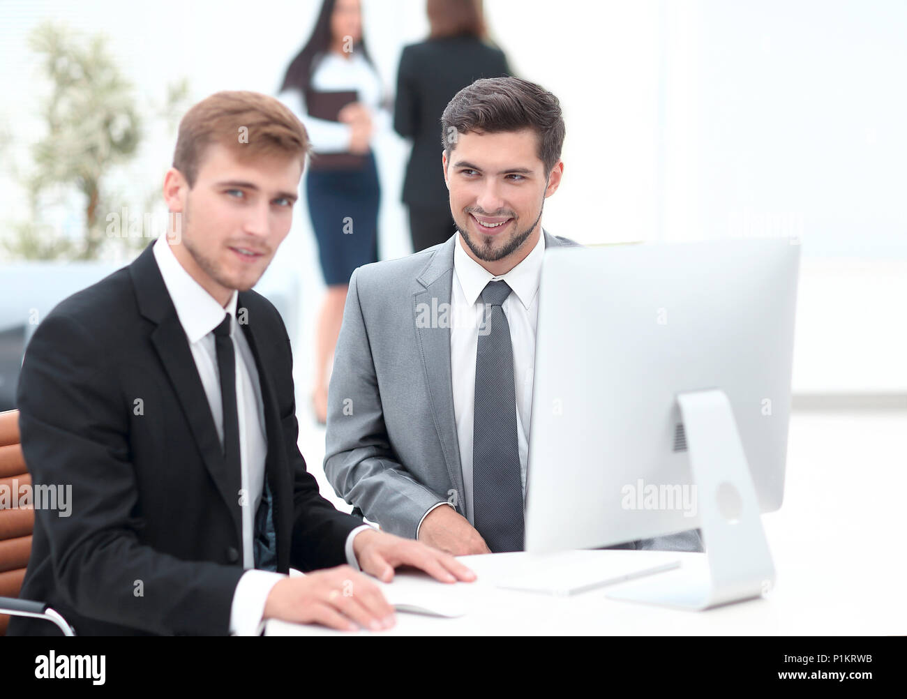 employees are talking sitting behind a Desk Stock Photo - Alamy