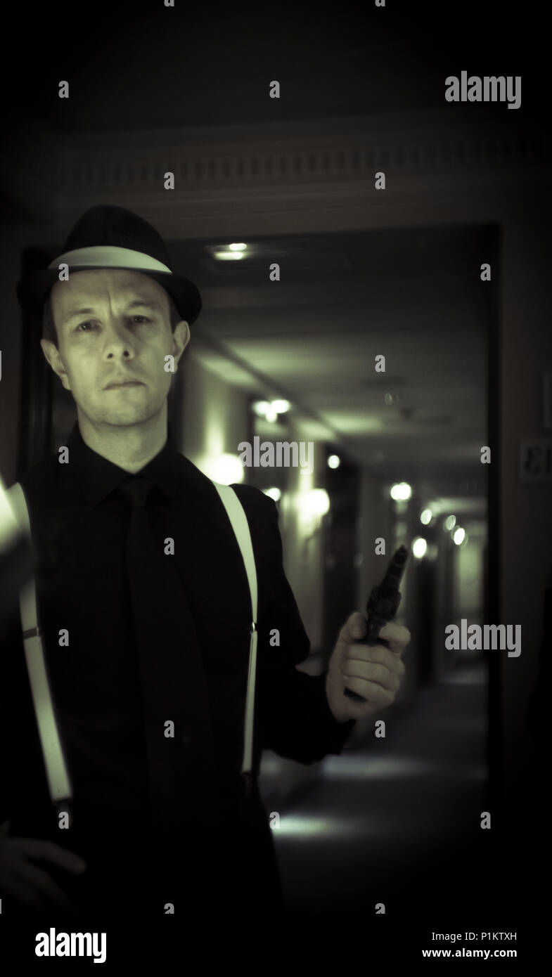 Ganster with gun in situation of alert and danger. Costume with hat ...