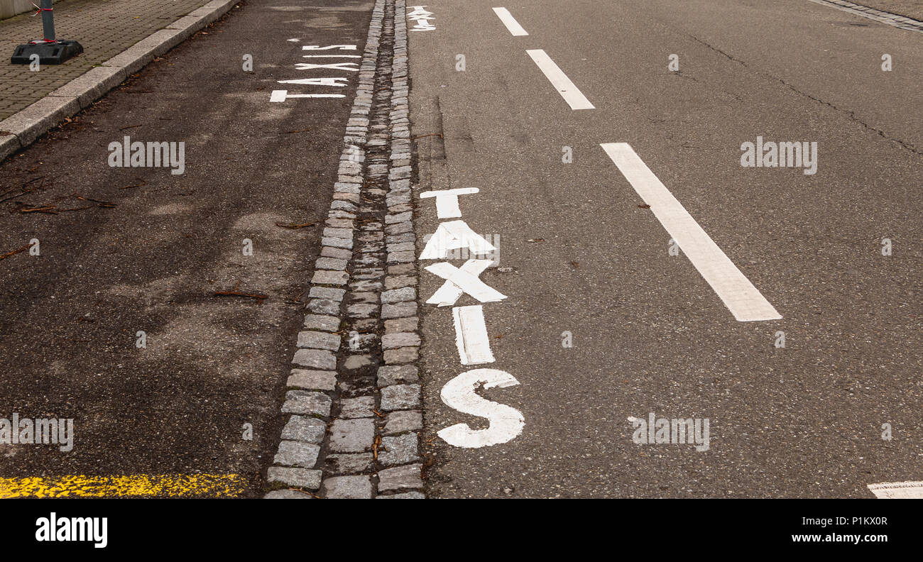 white painted taxi sign on a black asphalt road in France Stock Photo ...