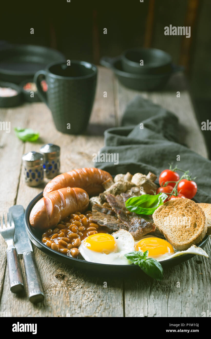 Full English breakfast with fried eggs, sausages, bacon, beans, toast ...