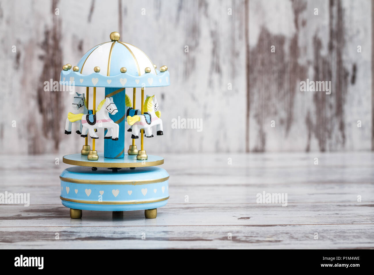 Blue carousel music box on white wooden background Stock Photo - Alamy