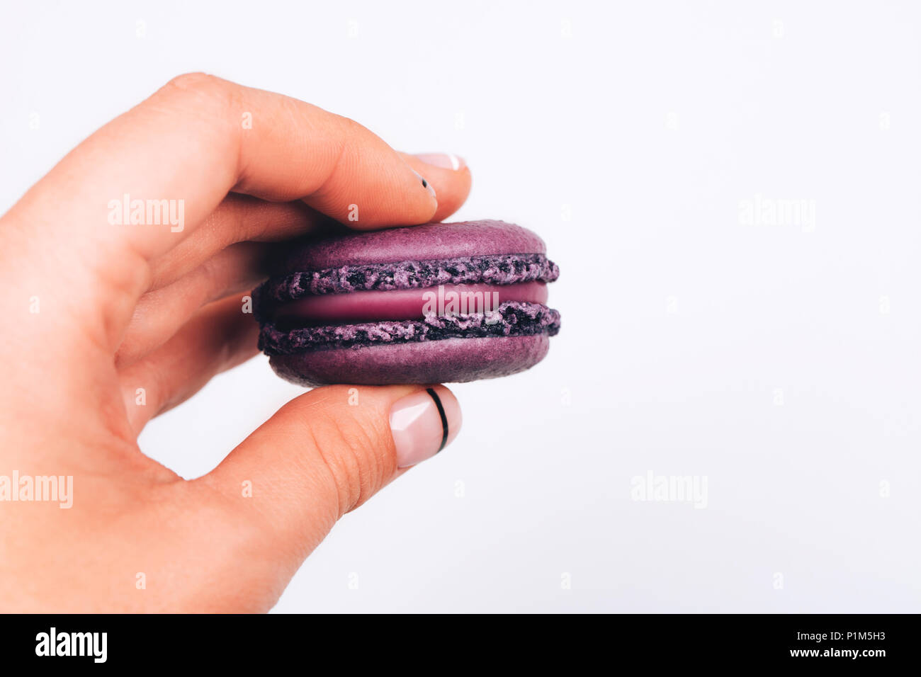 Hand with macaron Stock Photo - Alamy
