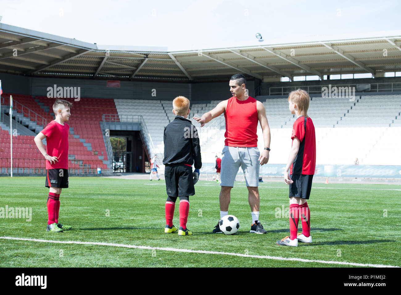 Football Coach Teaching Kids Stock Photo - Alamy