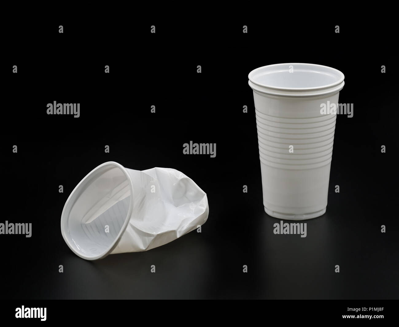 Crushed and new plastic cups isolated on black background Stock Photo ...