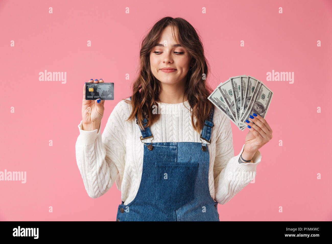 Portrait of a confident young girl holding money banknotes and showing ...