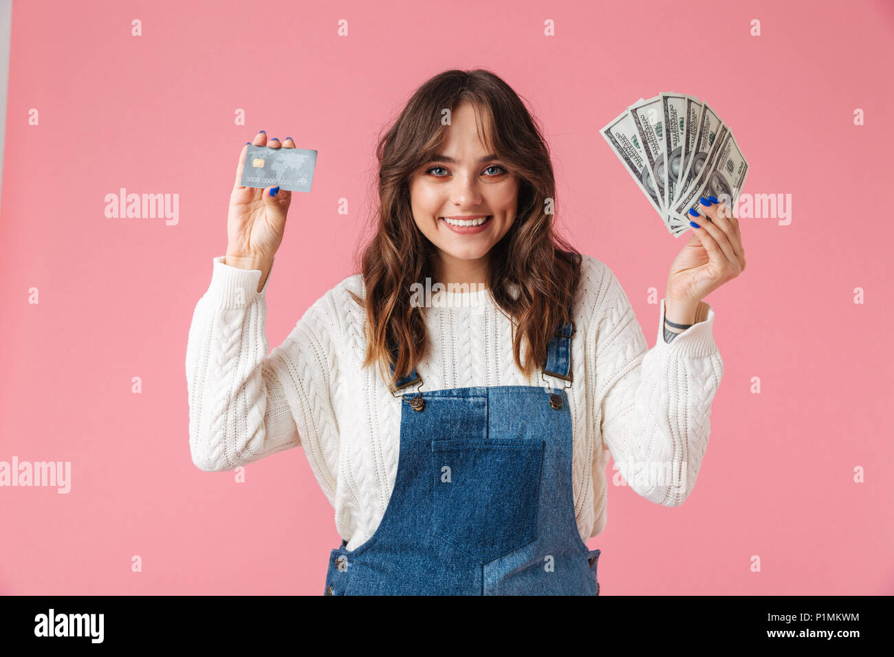 Portrait of an excited young girl holding money banknotes and showing ...