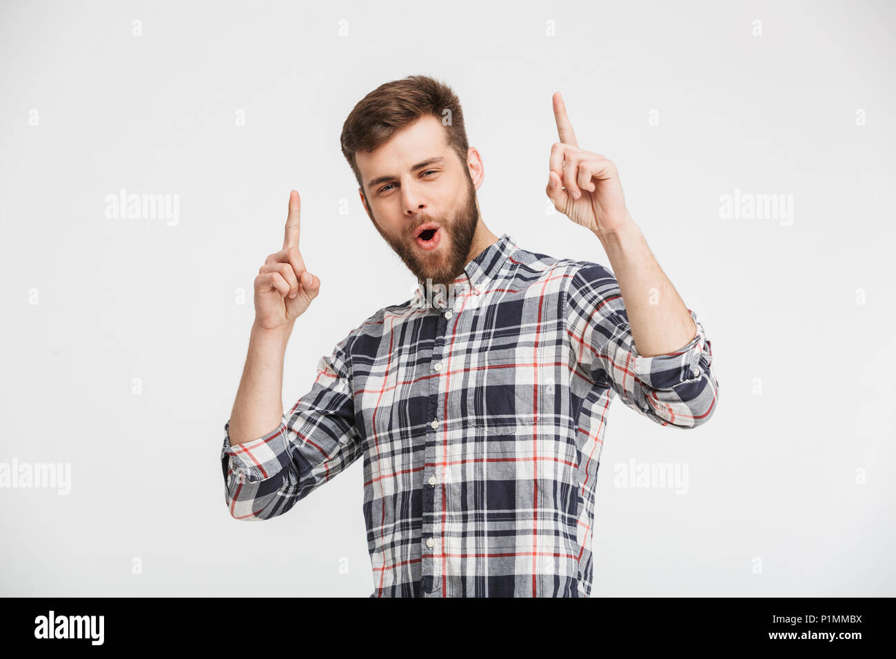 Portrait of an excited man pointing fingers up at copy space isolated ...