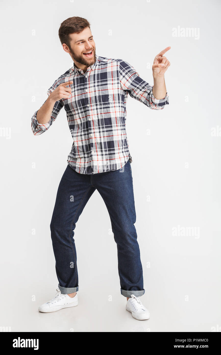 Full length portrait of a cheerful man pointing fingers away at copy ...