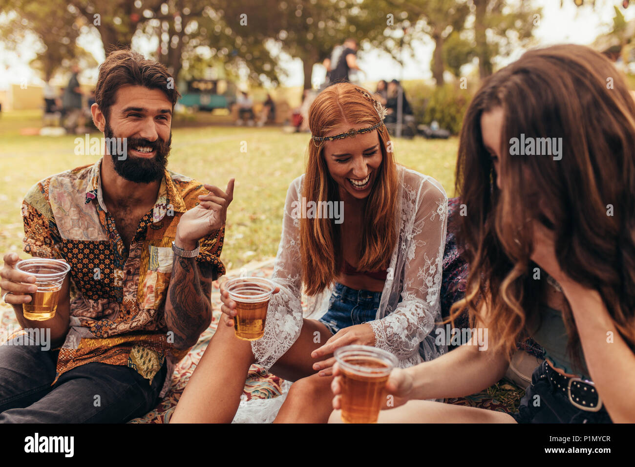 Happy friends partying at park with drinks. Group of friends having a ...
