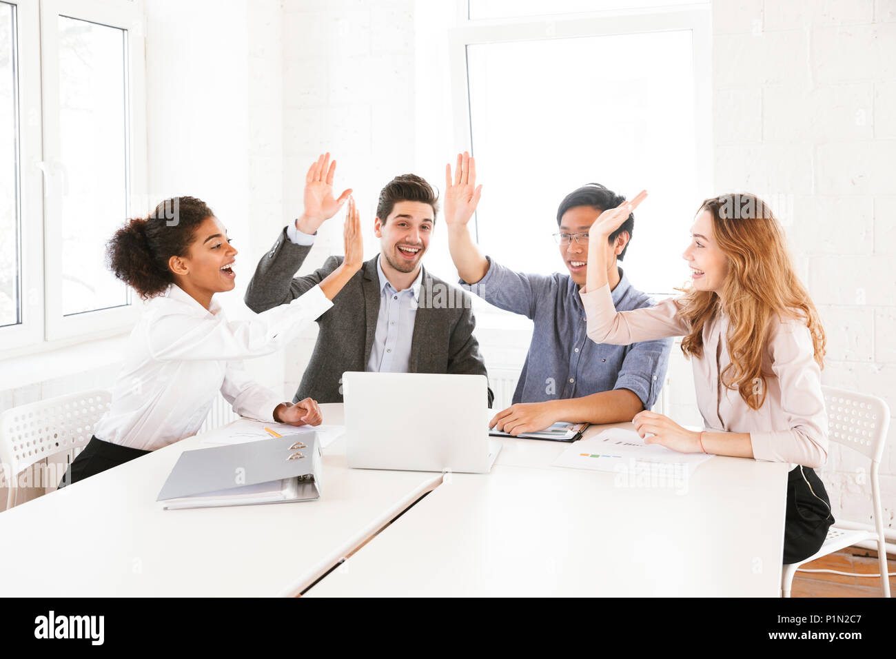 Group of smiling young multiethnic businesspeople discussing ideas ...