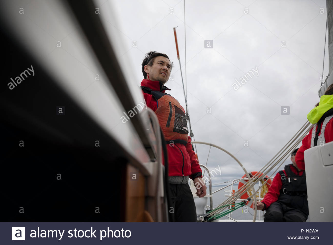 Man standing on sailboat Stock Photo - Alamy