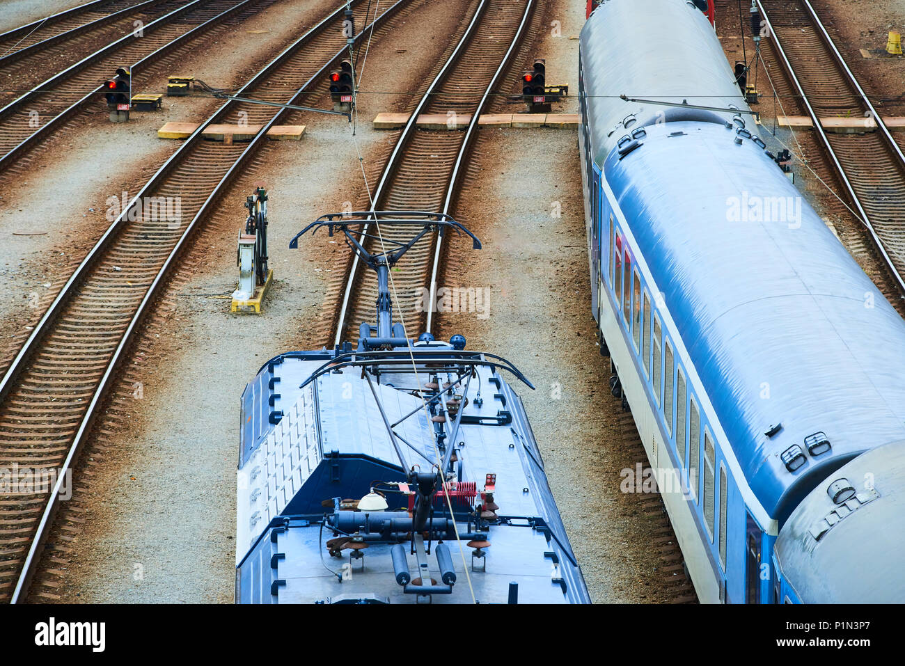 Electric locomotive and a train standing on the railroad tracks Stock ...