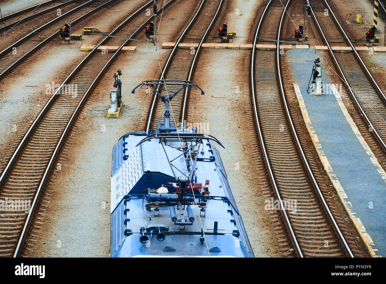 Electric locomotive and a train standing on the railroad tracks Stock ...