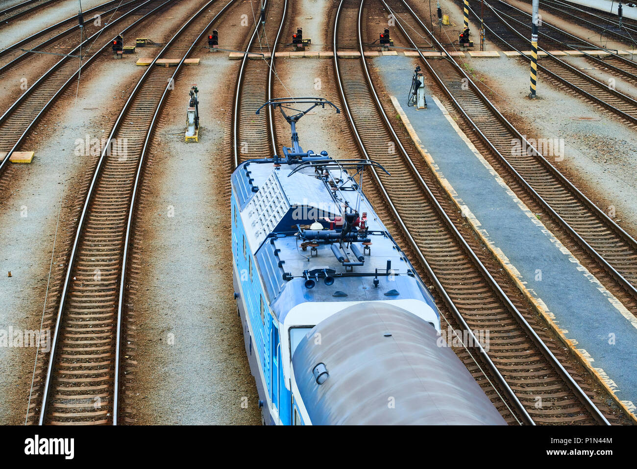Electric locomotive and a train standing on the railroad tracks Stock ...