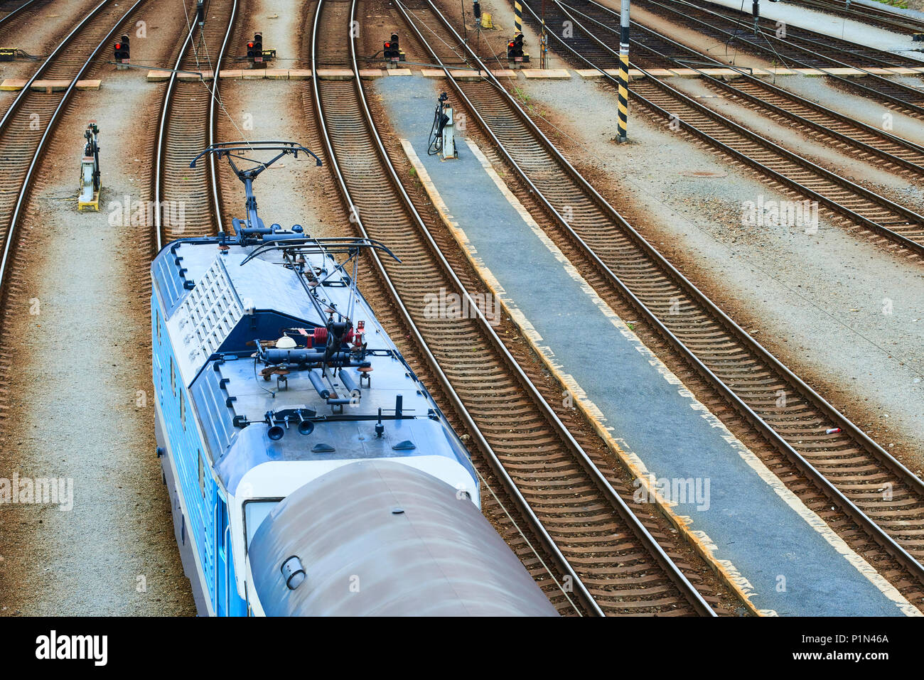 Electric locomotive and a train standing on the railroad tracks Stock ...