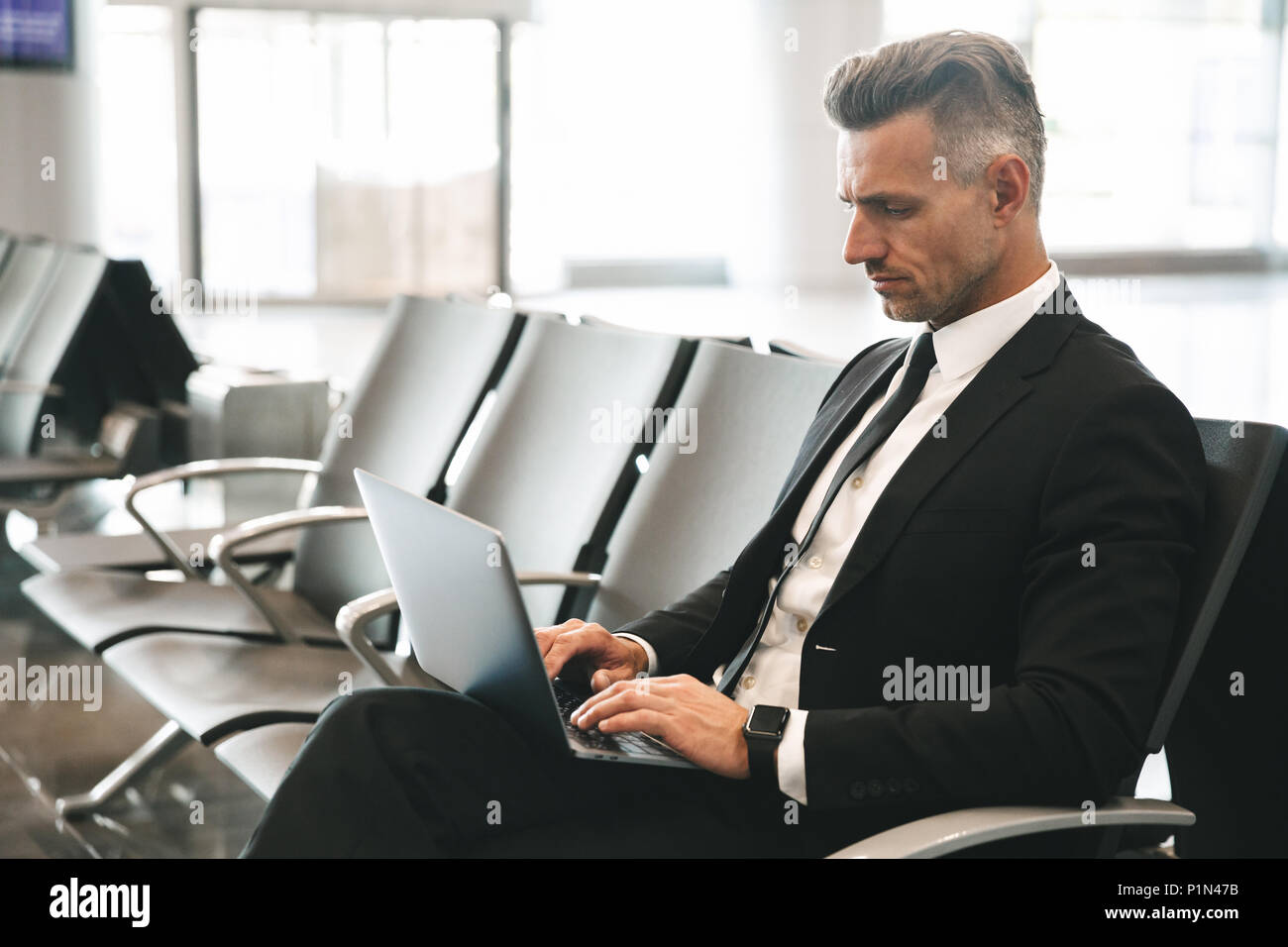 Businessman using laptop airport departure hi-res stock photography and ...