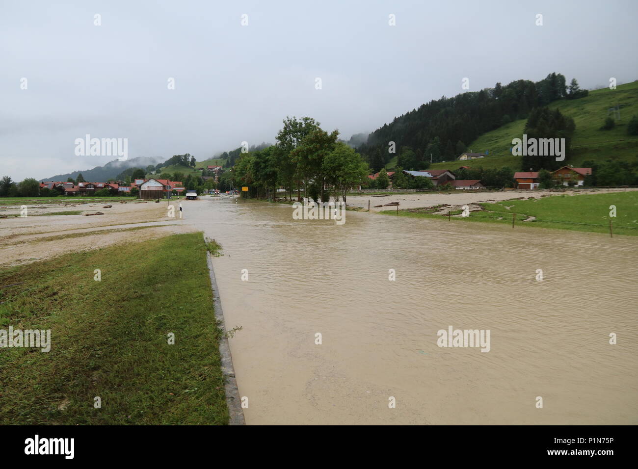 12 June 2018, Germany, Rettenberg: Water flows over a road in the ...
