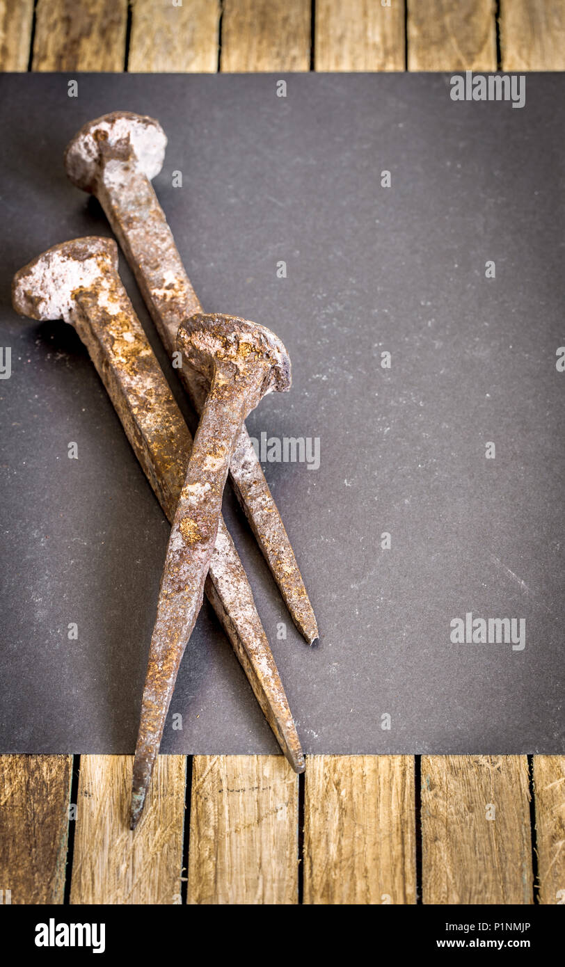 very old large nails on a beautiful wooden background, rusty nails ...