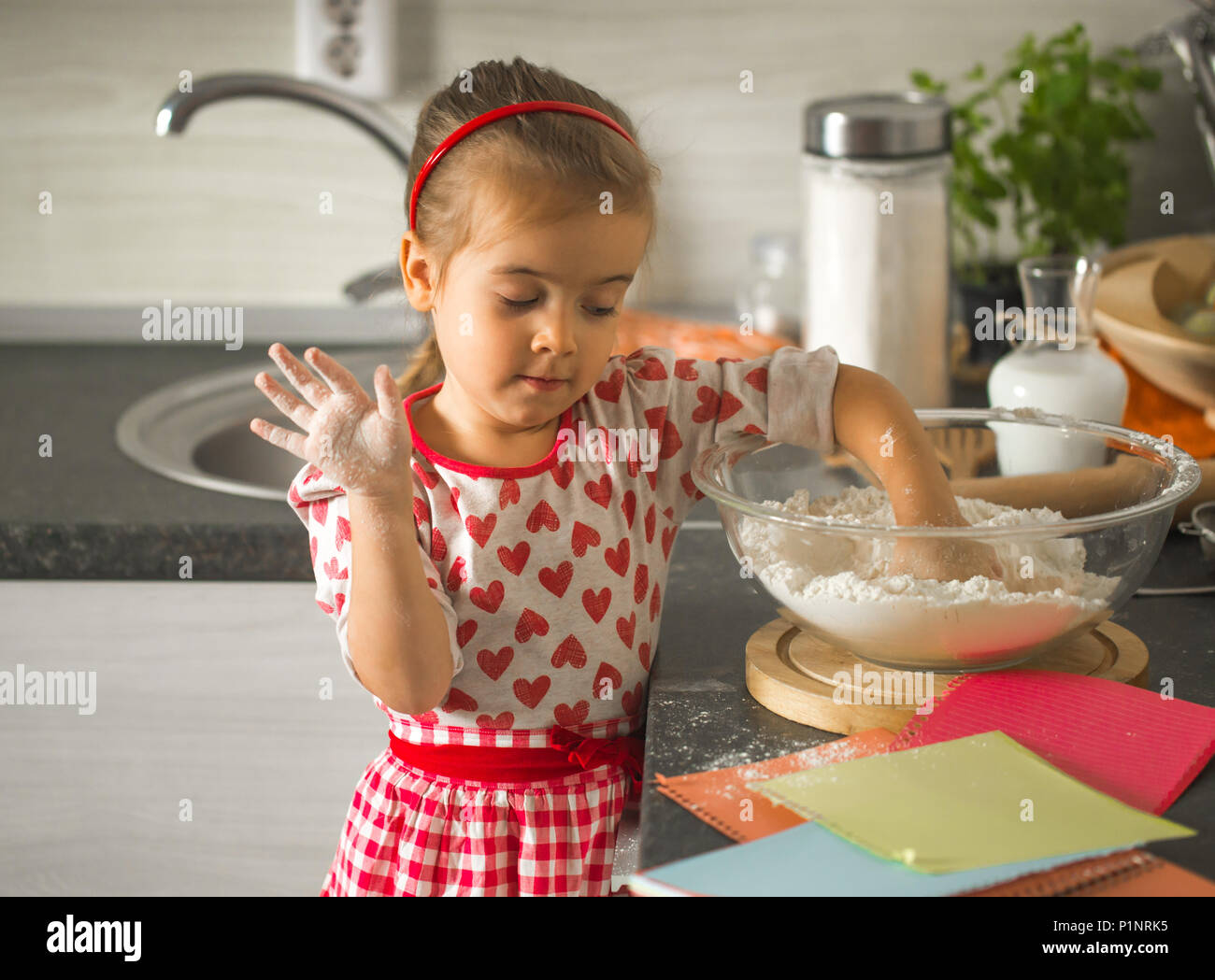 beautiful little girl Baker on kitchen with ingredients for baking ...