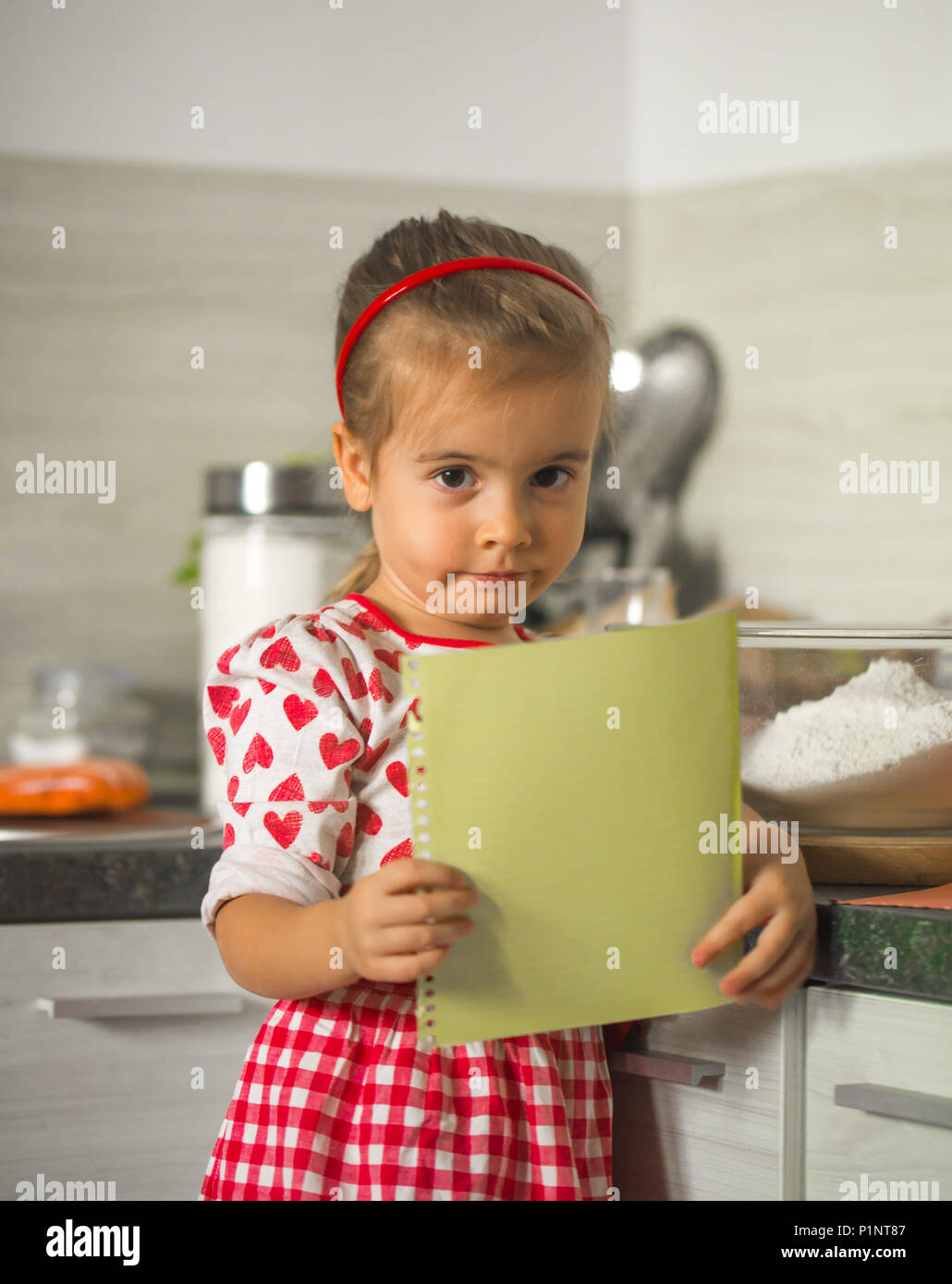 beautiful little girl Baker on kitchen with ingredients for baking ...