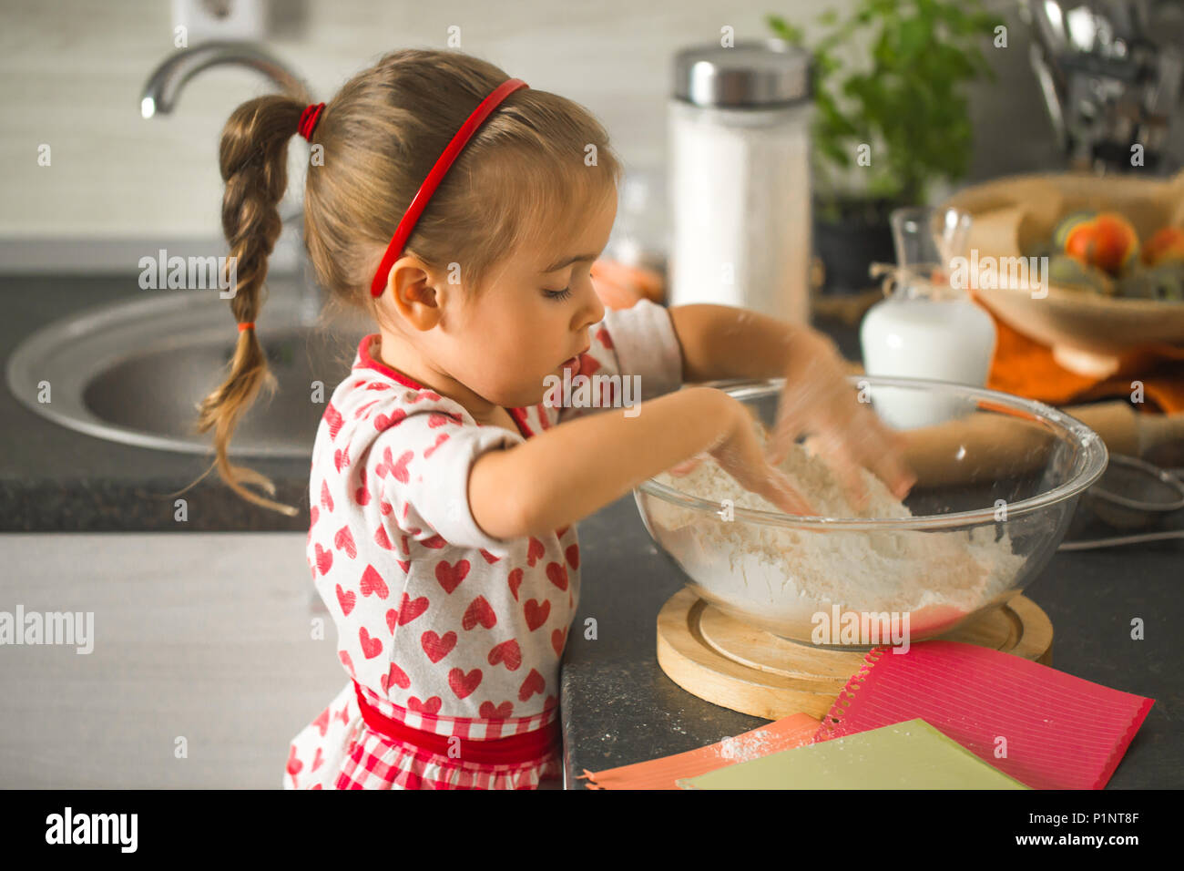 beautiful little girl Baker on kitchen with ingredients for baking ...