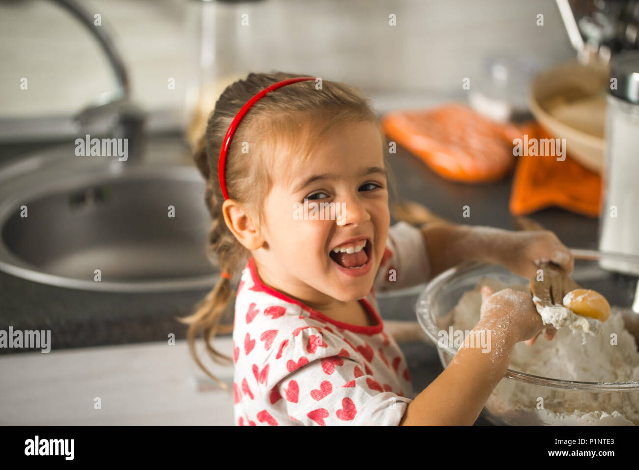 beautiful little girl Baker on kitchen with ingredients for baking ...