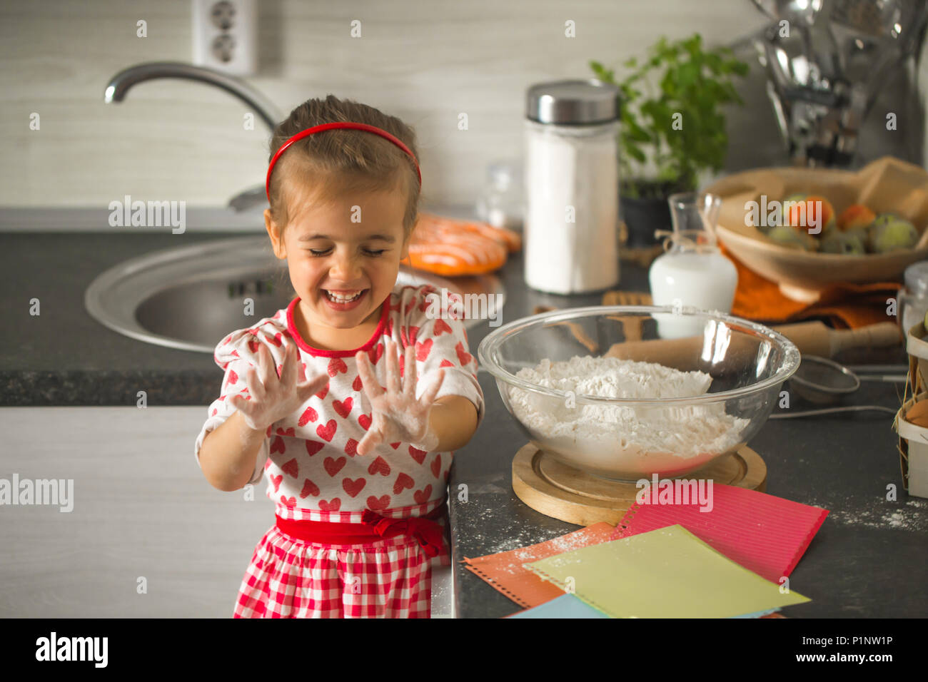 beautiful little girl Baker on kitchen with ingredients for baking ...