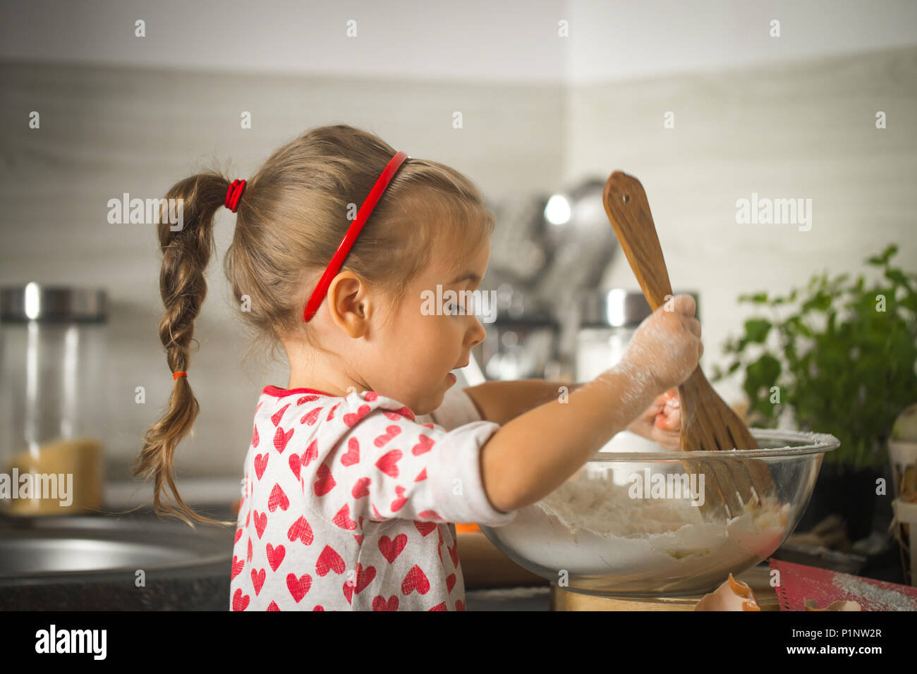 beautiful little girl Baker on kitchen with ingredients for baking ...