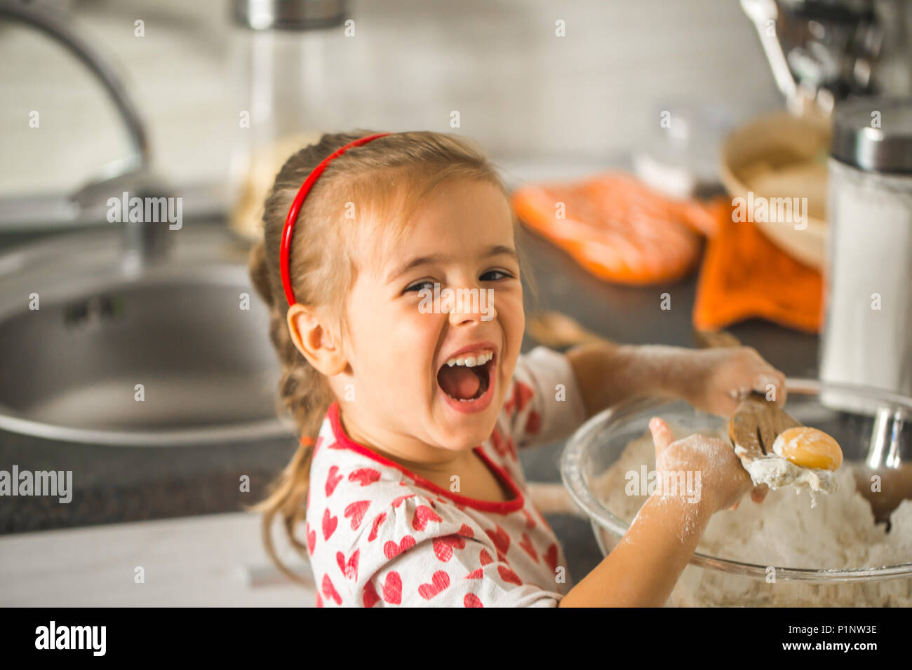 beautiful little girl Baker on kitchen with ingredients for baking ...