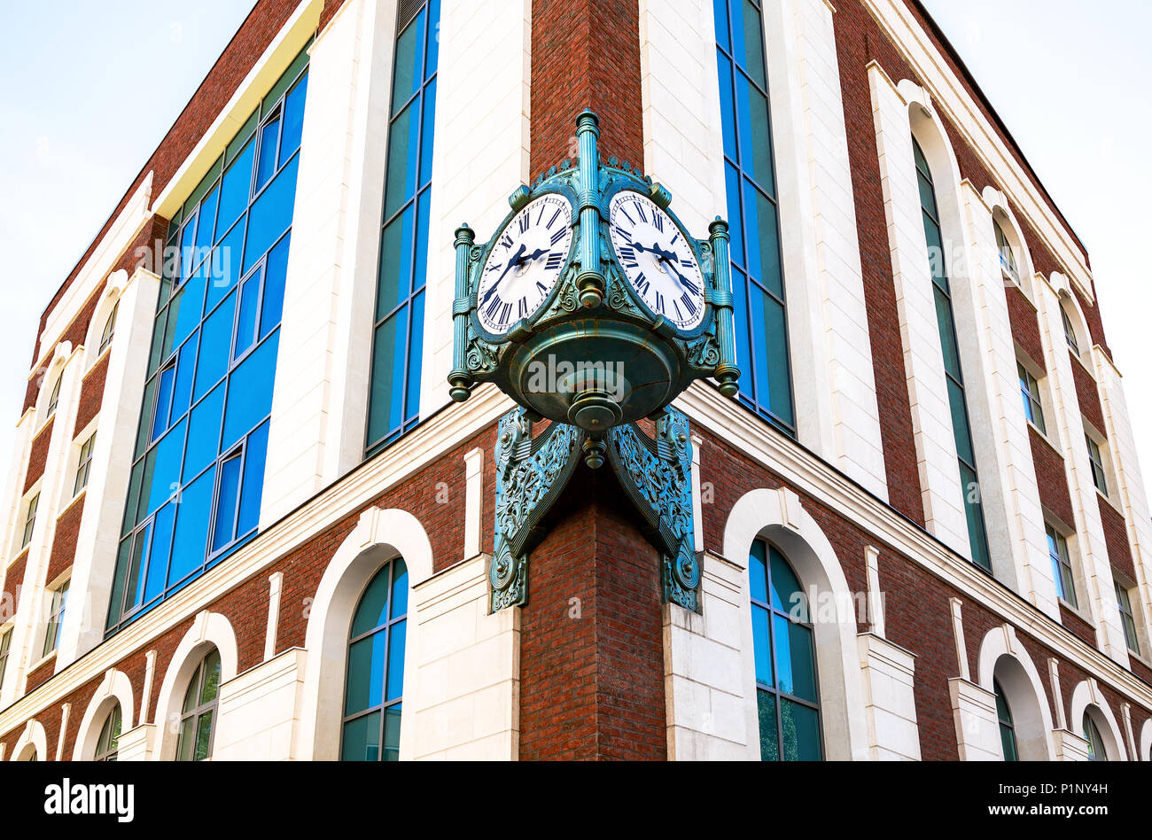 Vintage decorative street clock hanging on a corner of brick building ...