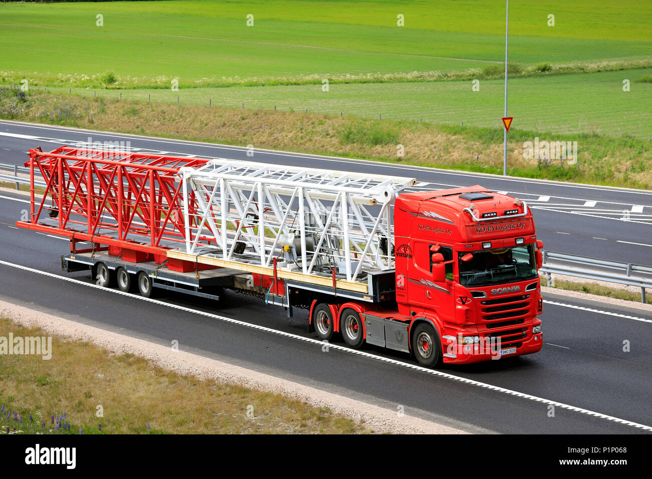 Red Scania semi truck of Ko-Pa Logistics Oy transports part of a crane ...