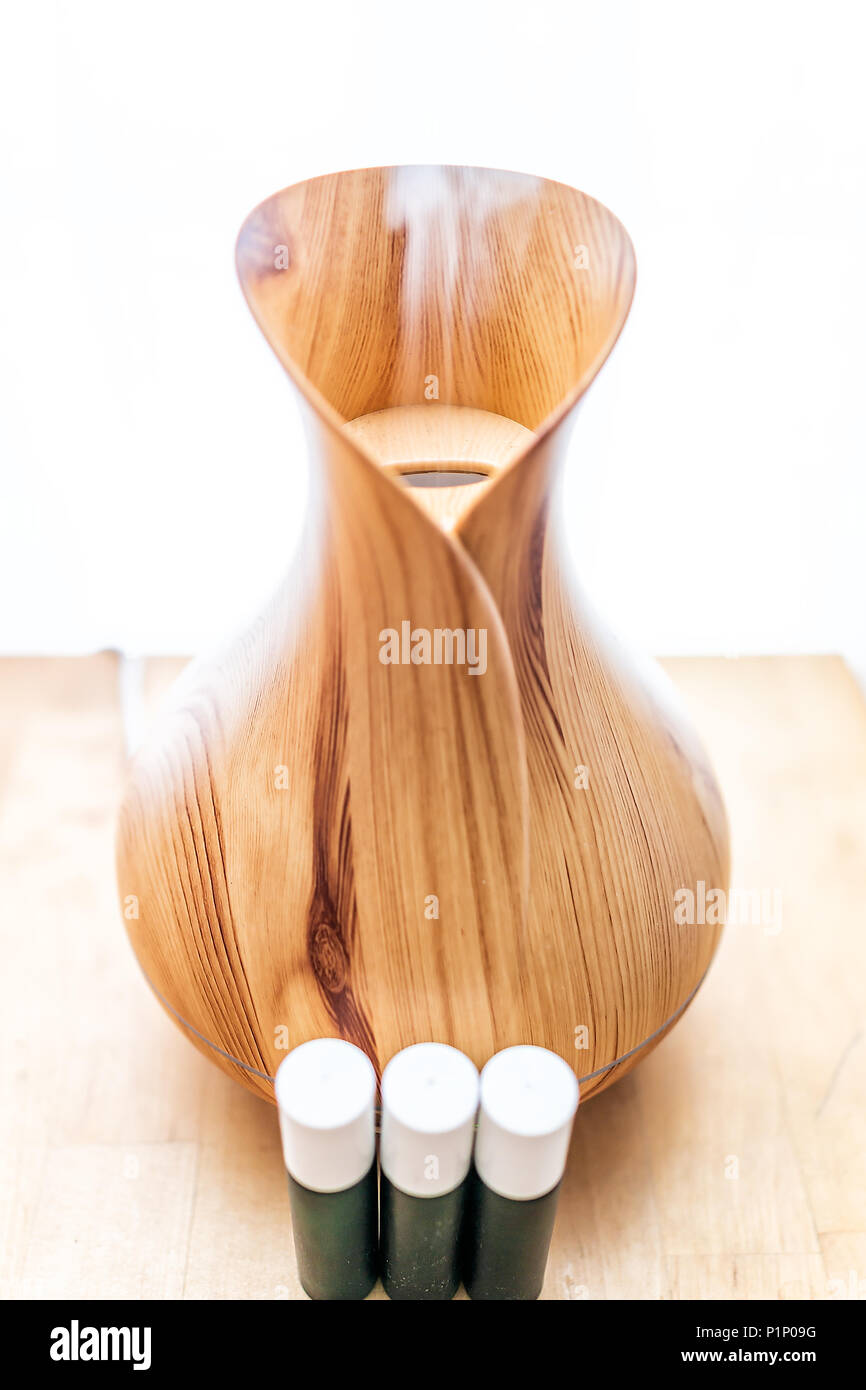 Wooden bamboo essential oil diffuser closeup, with three green glass ...
