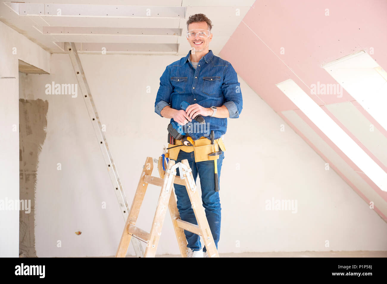 Portrait of smiling construction man wearing protective eye googles ...