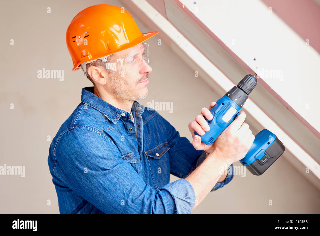 Portrait of repairman man wearing safety helmet while working with ...