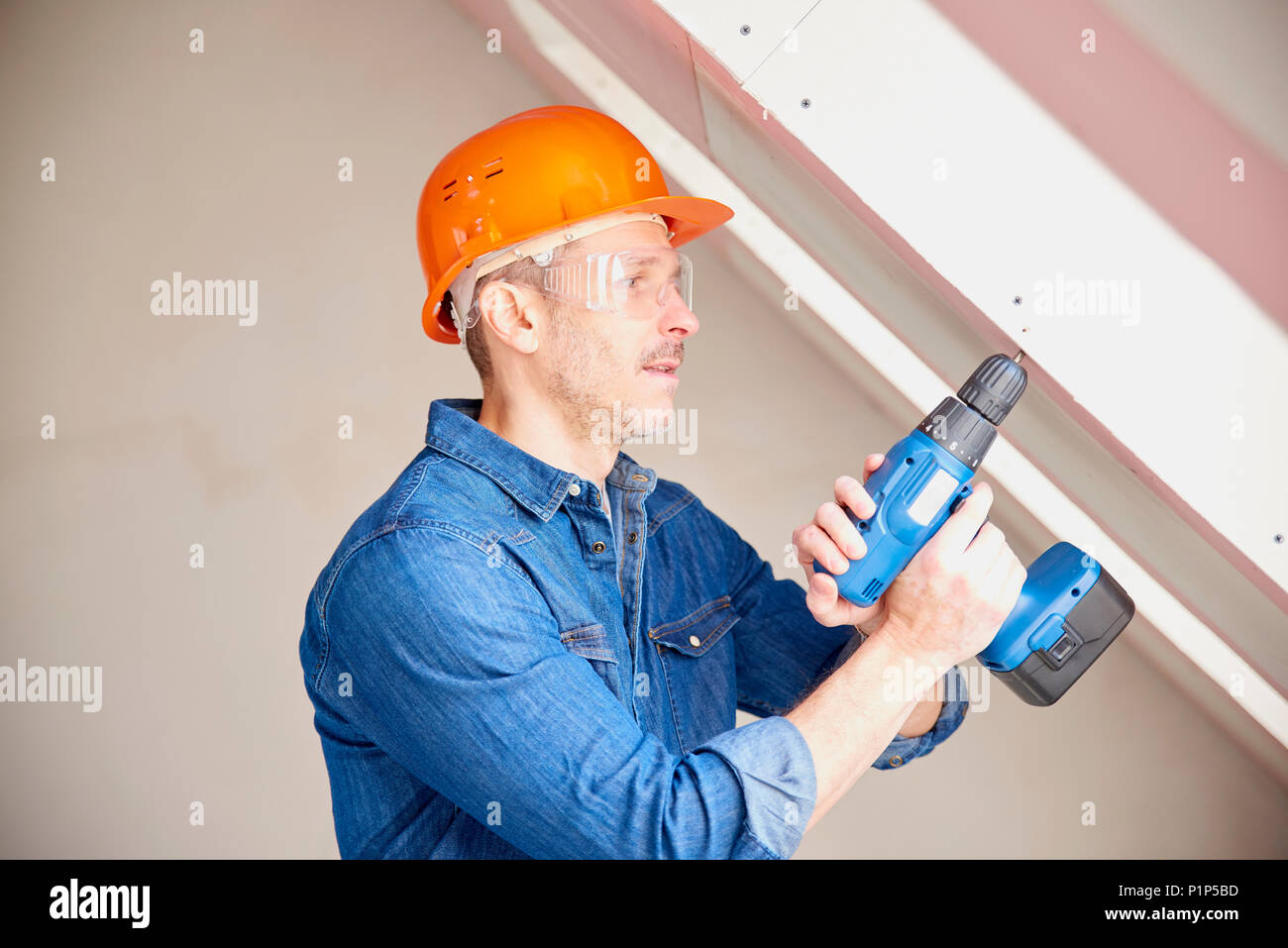 Portrait of repairman man wearing safety helmet while working with ...