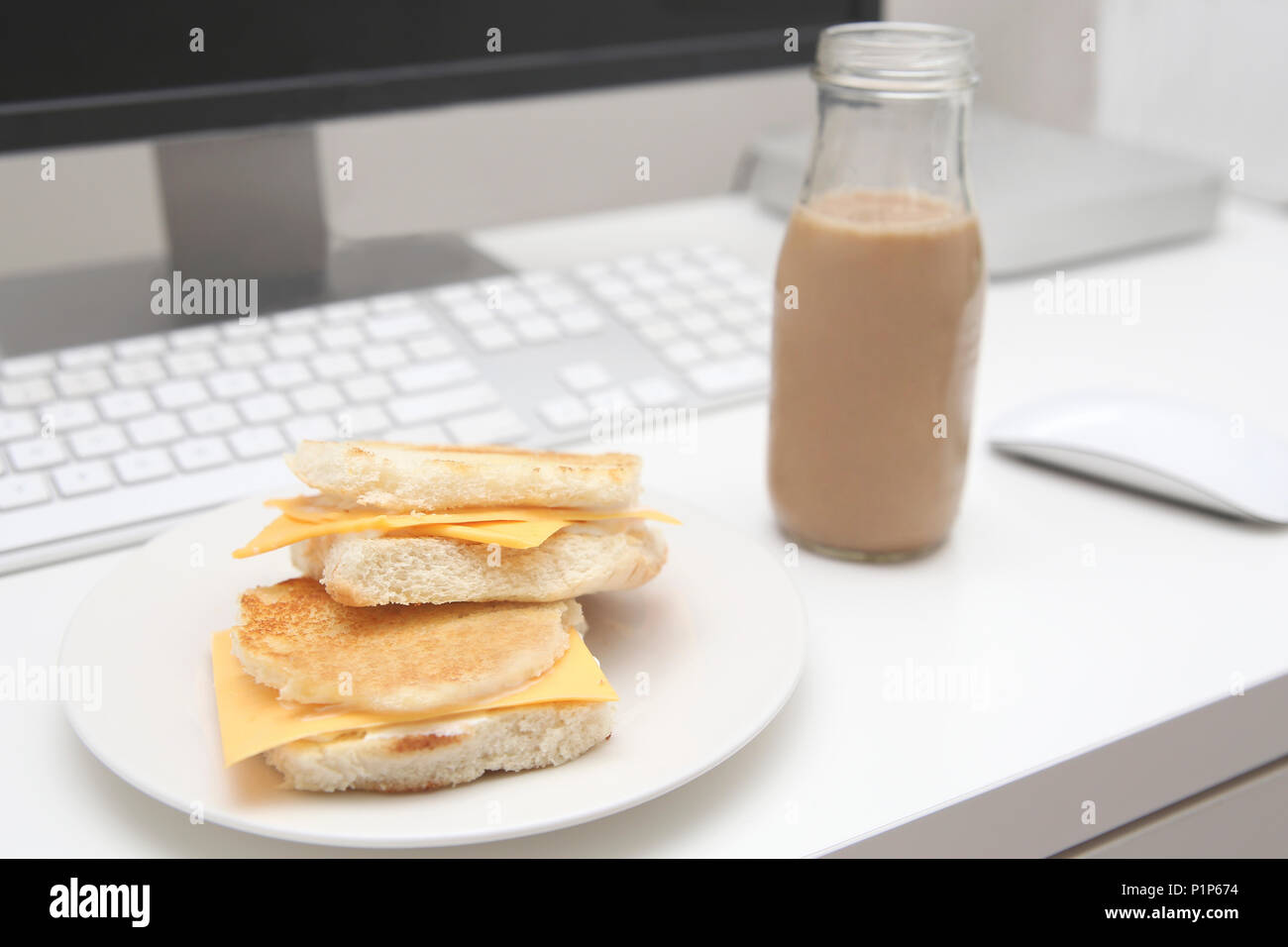 Lunchtime at a modern office desk. Delicious cheese sandwich and a ...