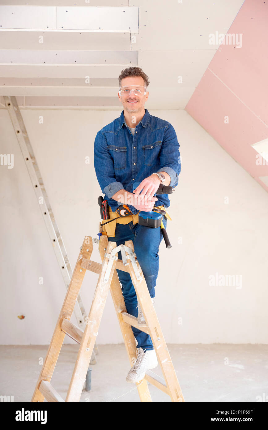 Full length shot of handsome middle aged handyman standing on the ...