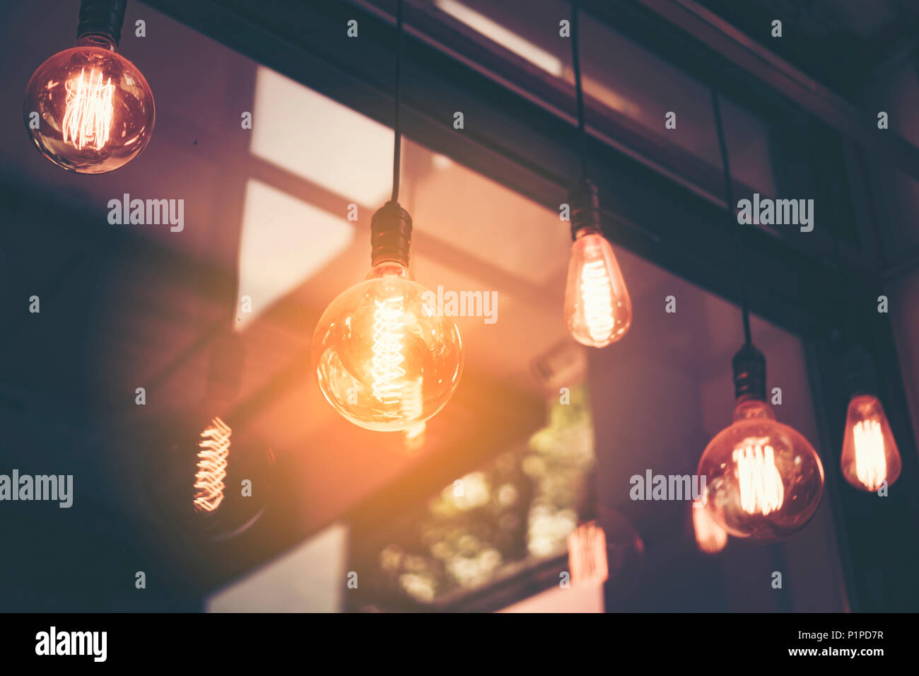 Decorative antique edison style light bulbs against cafe wall ...