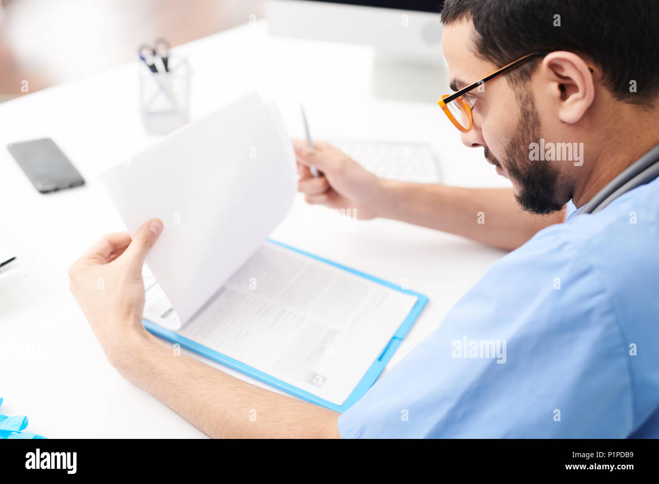 Doctor filling in checkup document hi-res stock photography and images ...