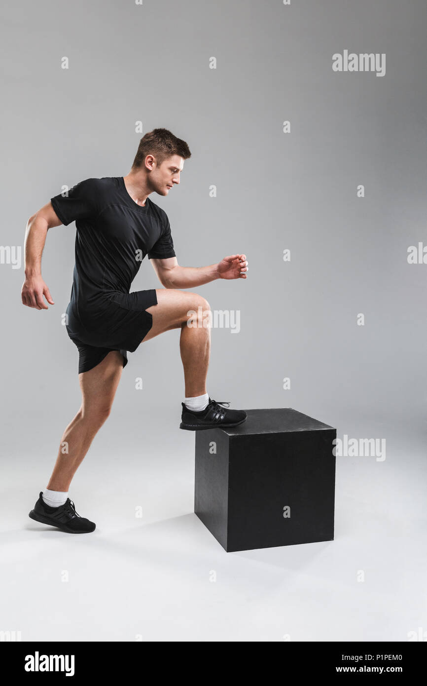 Full length portrait of a concentrated young sportsman stepping on a ...