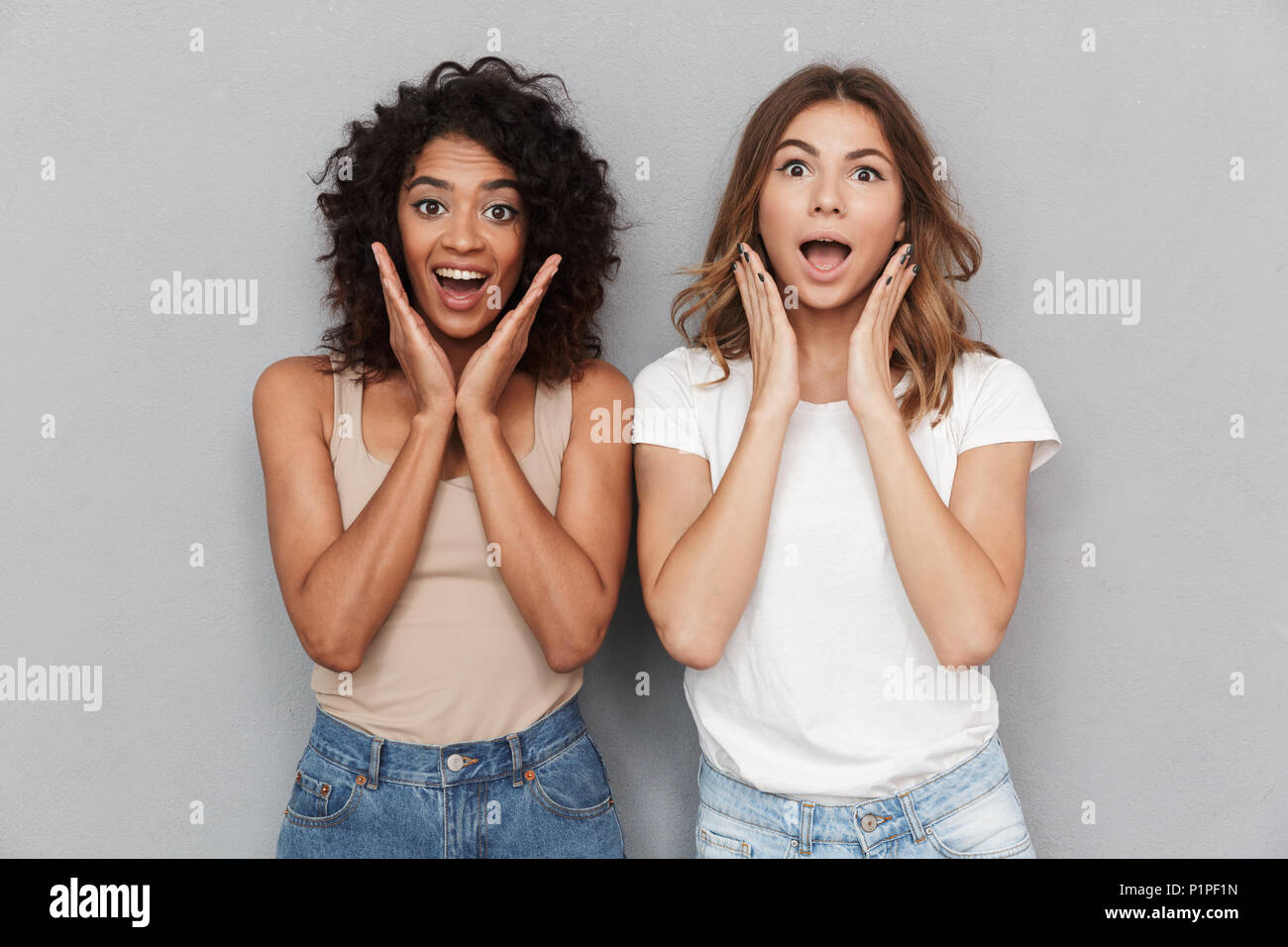 Portrait of two excited young women standing together and screaming ...