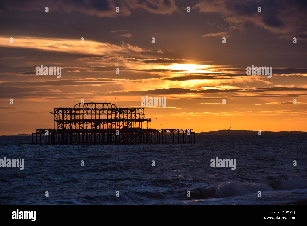 The sun setting behind Brighton's famous West Pier ruins Stock Photo ...
