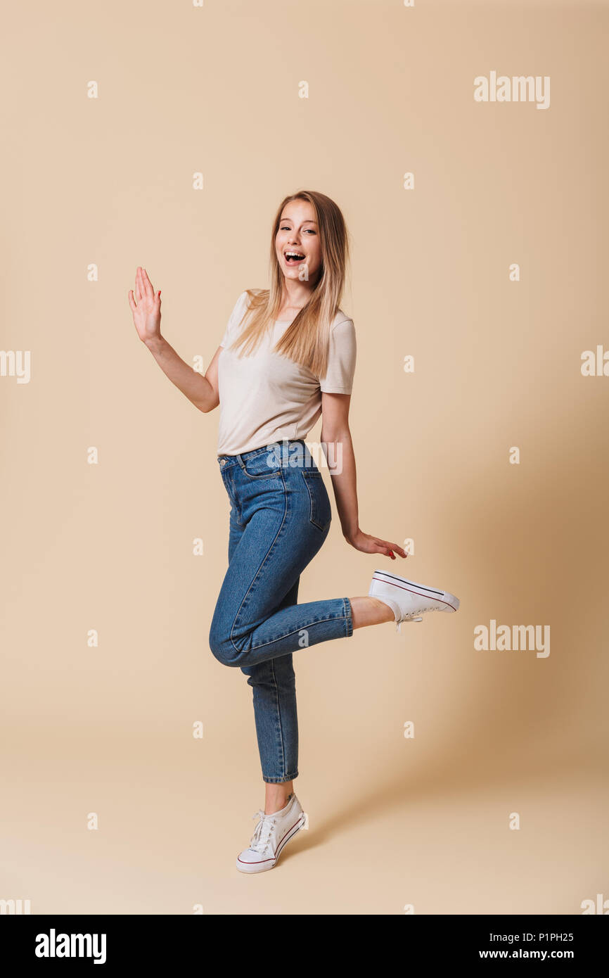 Full length portrait of a cheerful casual girl posing while standing ...